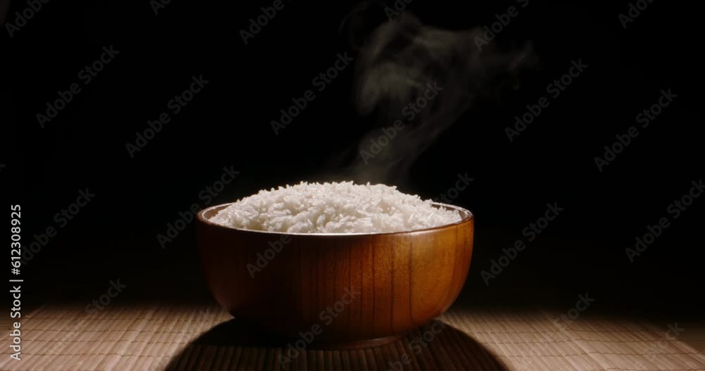 Hot white cooked rice steam bowl black background slow motion, Close up ...