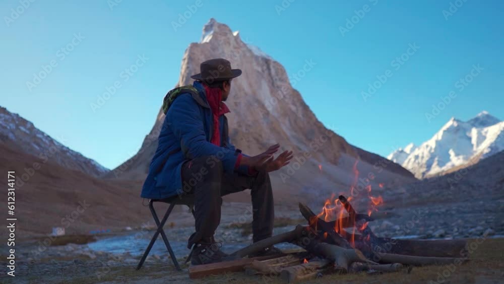 Indian male tourist sitting besides the bonfire in front of the Holy ...