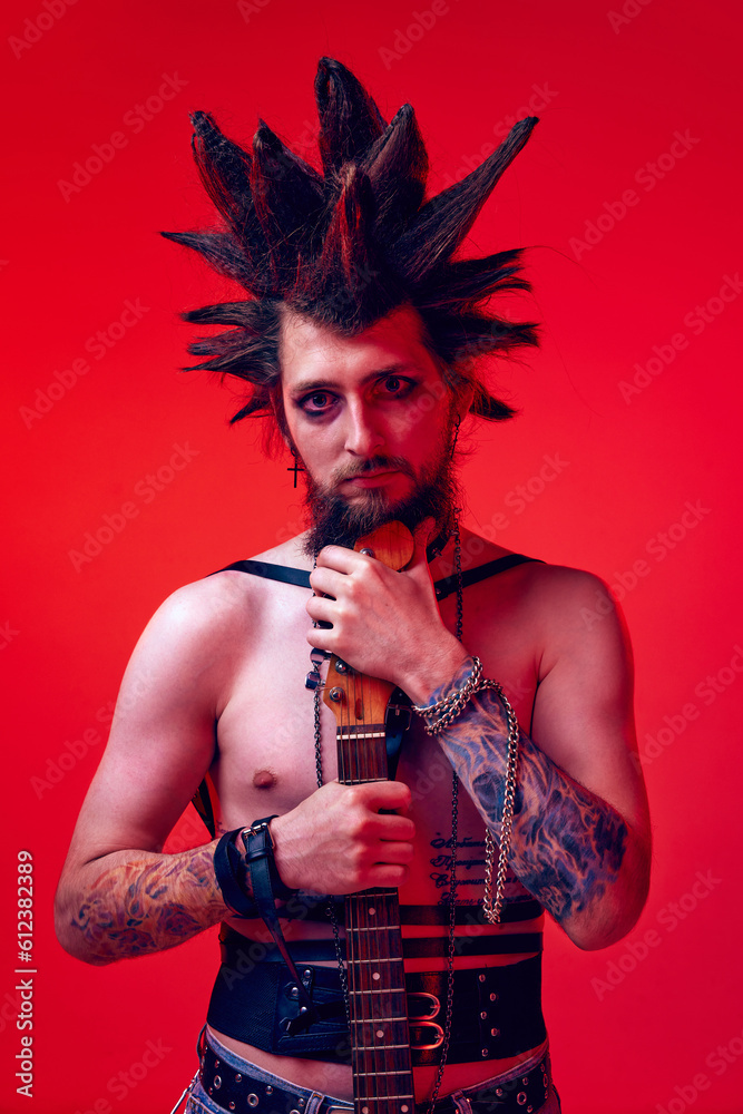 Deep look. Portrait of creative young man, punk, musician posing with ...