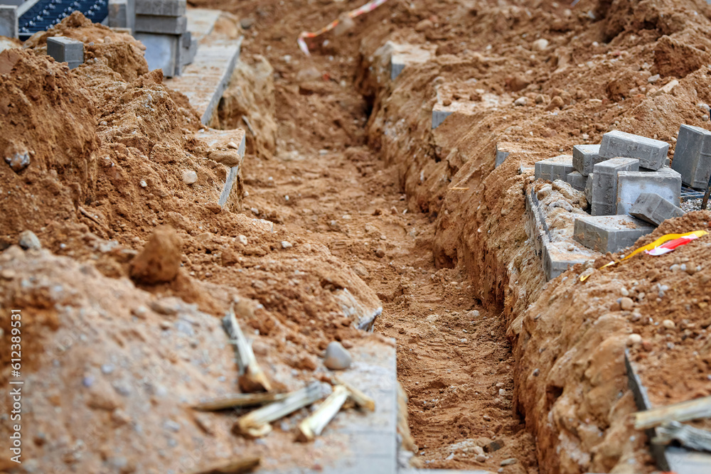 Trench in paved sidewalk for laying communications, electric cable ...