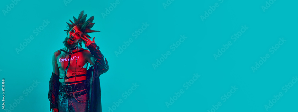 Rock musician, punk with neon filter reflection on body, posing on blue ...