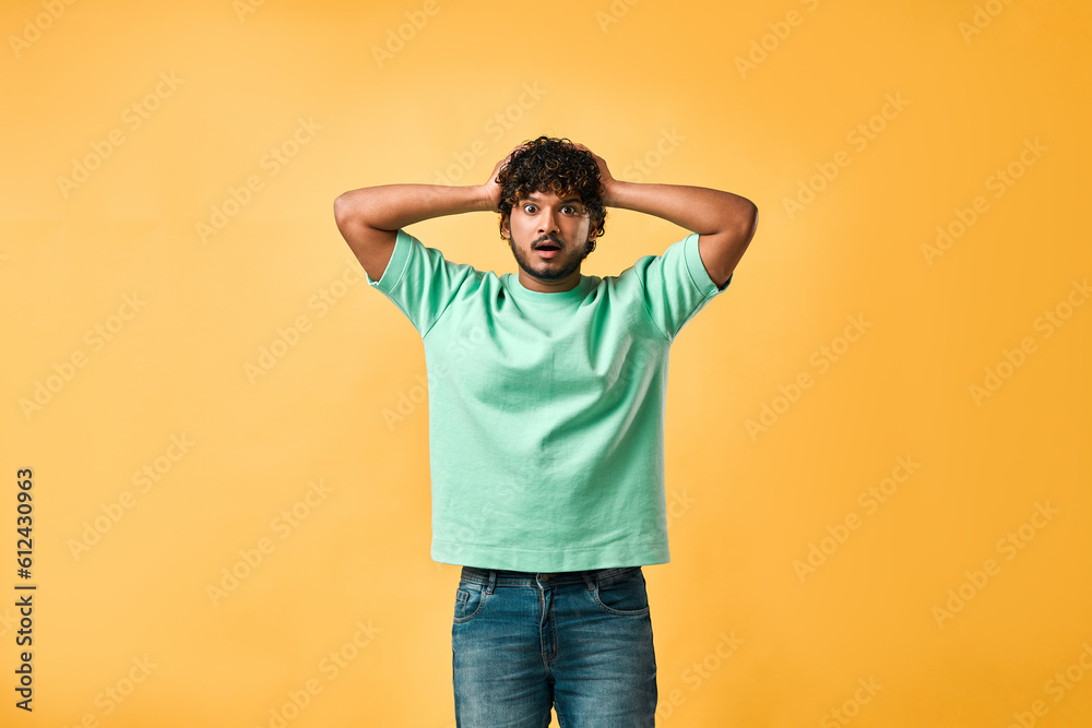 Handsome Indian man showing emotion of fright, fear and shock holding ...