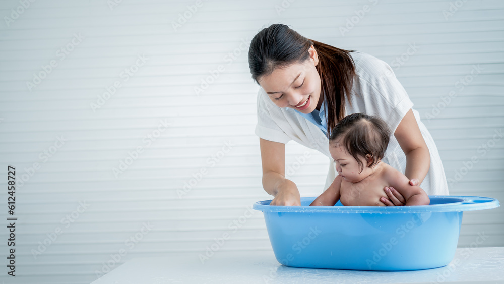Asian mother Bathing her 7-month-old daughter, which the baby smiling ...