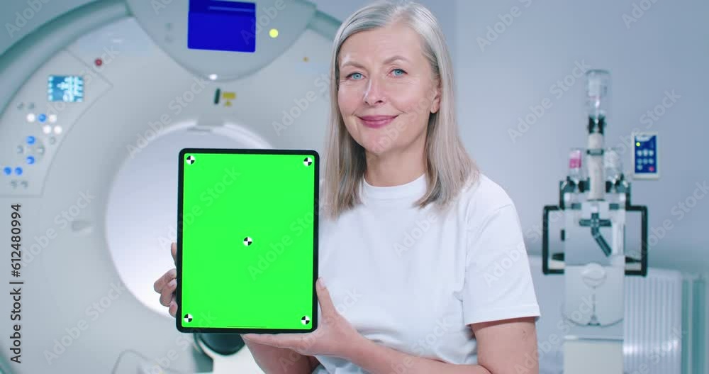 Close-up of woman sitting at TC scanner bed. Mature female at room of ...