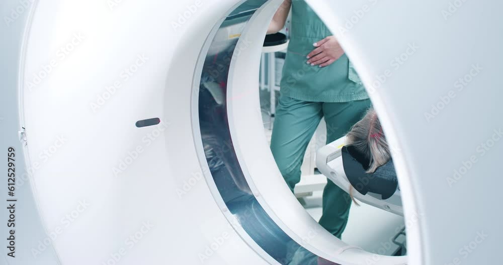 Close-up of back shoot of woman entering in MRI capsule. Patient is ...