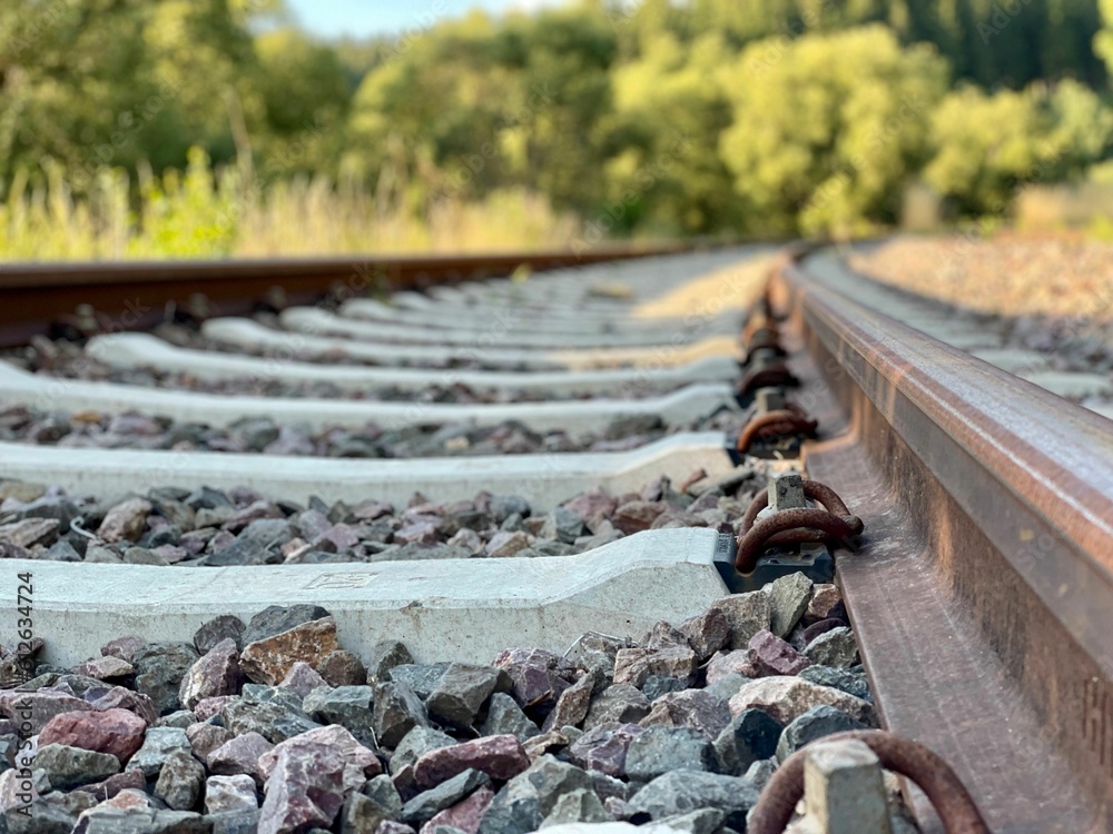 rail tracks are lined with gray stones and gravel the end is brown ...