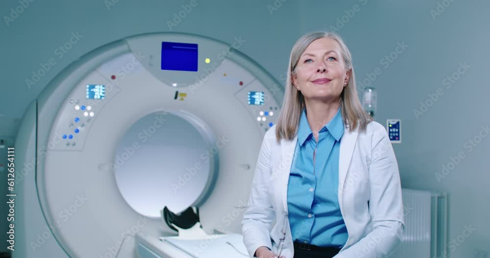 Portrait of smiling female doctor at background of MRI capsule. Middle ...