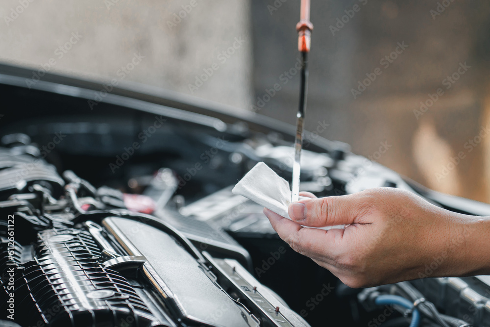 Man hold dipstick to check the engine oil level of engine and use white ...