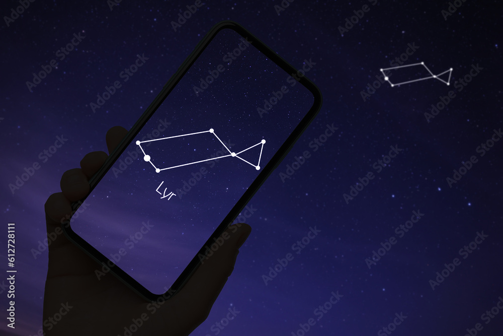 Woman using stargazing app on her phone at night, closeup. Identified ...
