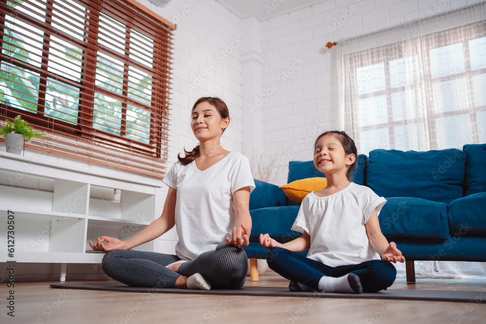 Mother and daughter exercising together happily at home. for ...