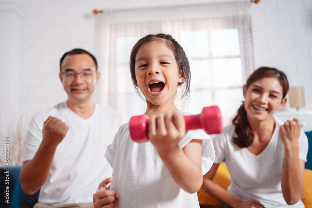 Family consisting of parents and daughters happily exercising together ...