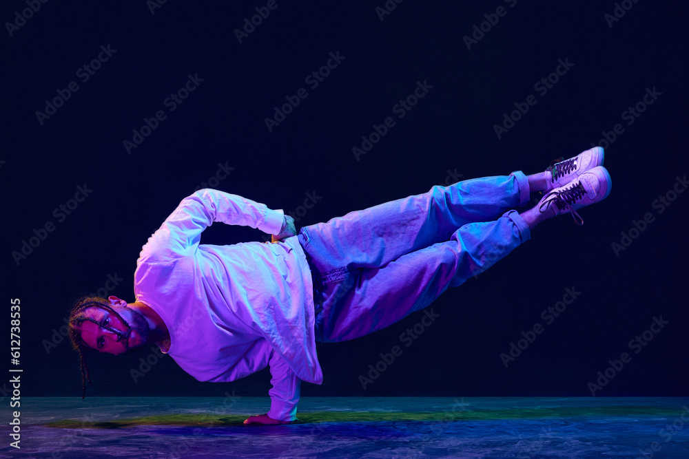 Strength. Young man in sport style clothes dancing hip-hop, breakdance ...