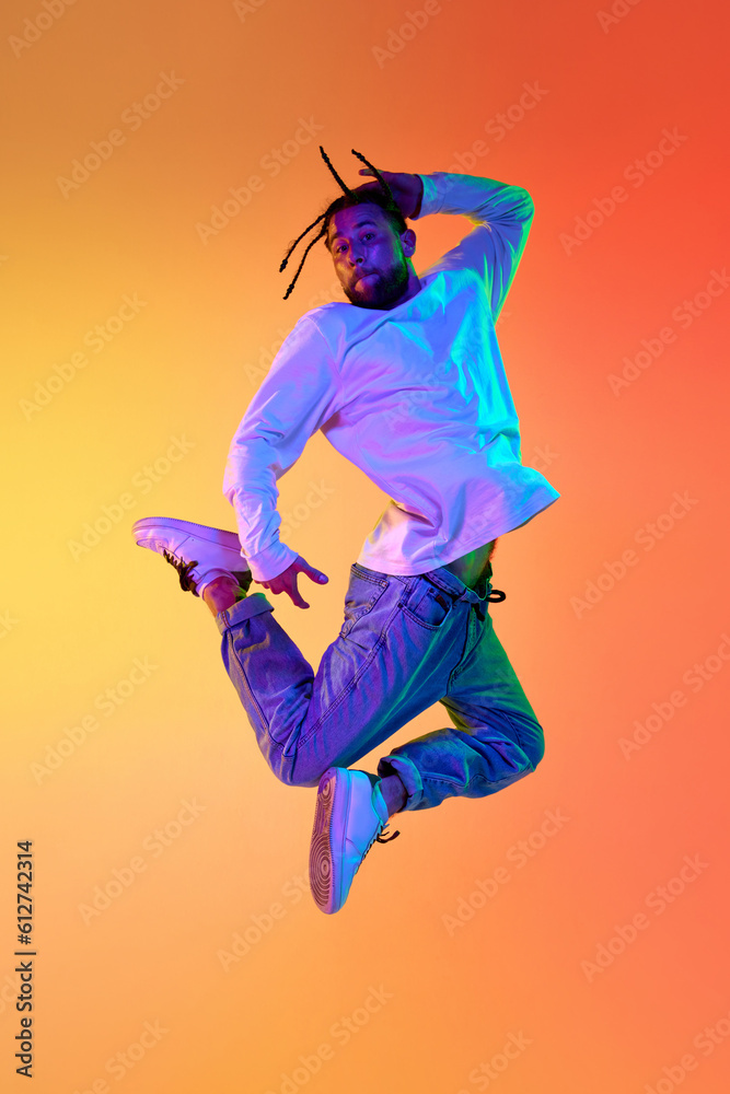 Young bearded man with dreads in casual clothes dancing breakdance ...