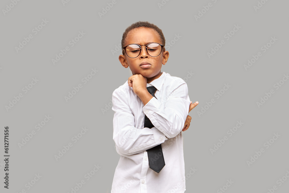 Portrait of smart intelligent schoolboy in spectacles standing with ...