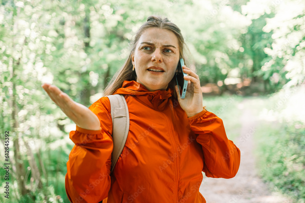 Foto de Angry woman tourist hiker hand holding smart phone searching ...