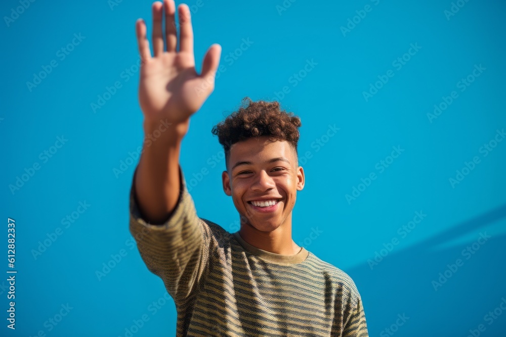 Lifestyle portrait photography of a joyful boy in his 20s waving with ...