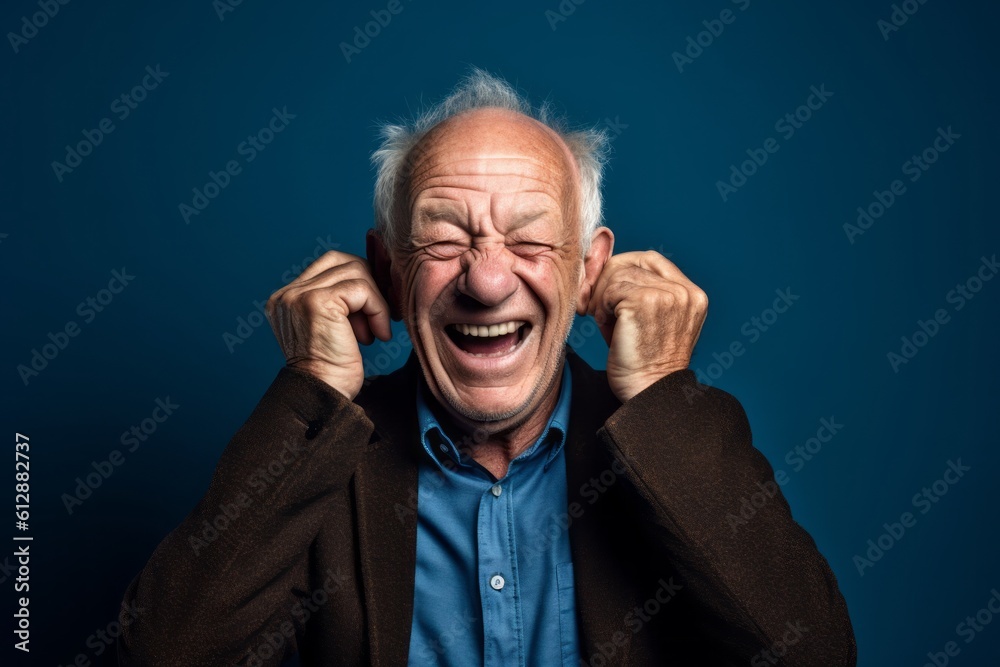 Headshot portrait photography of a grinning old man covering his ears ...