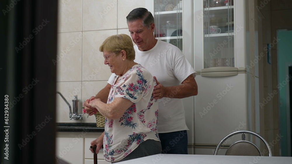 Caretaking moment of middle-aged son helping elderly mother get up from ...