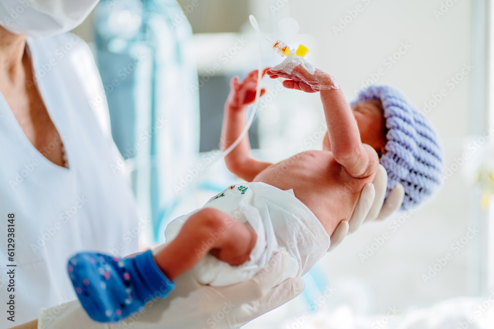 Premature baby hand with a catheter. Unrecognizable female nurse ...