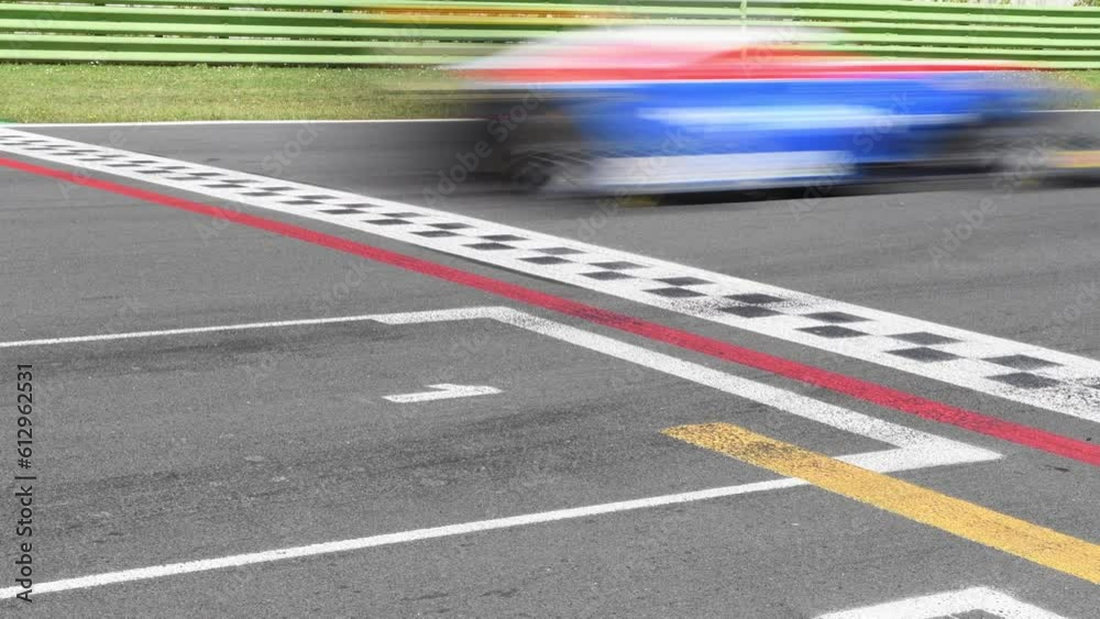Racing cars crossing checkered finish line with number one sign on ...