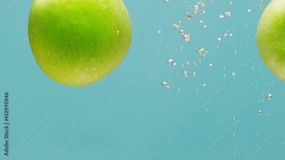 Green apple falling in boiling water, fresh sliced fruits and ...