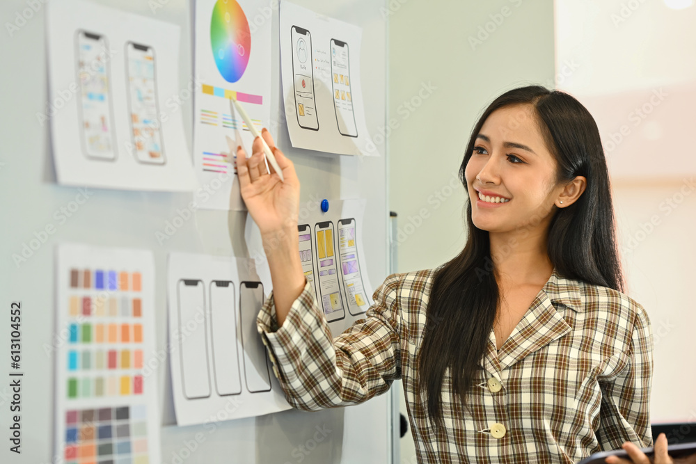 Foto de Beautiful female UX designer presenting sketch designs ...