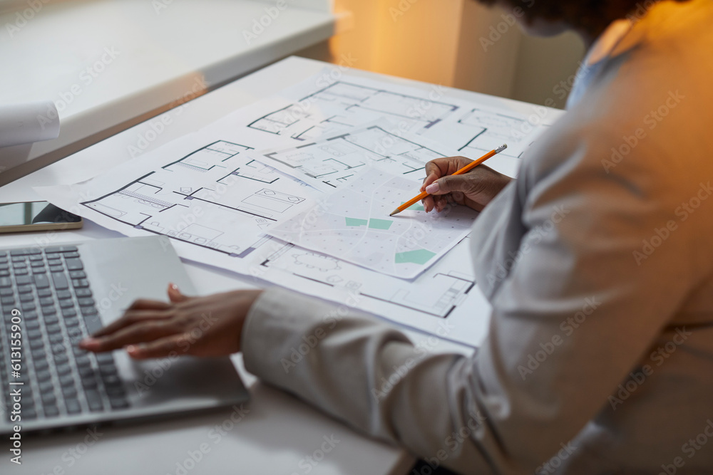 Female architect working with blueprints, cadastral maps and city plans ...