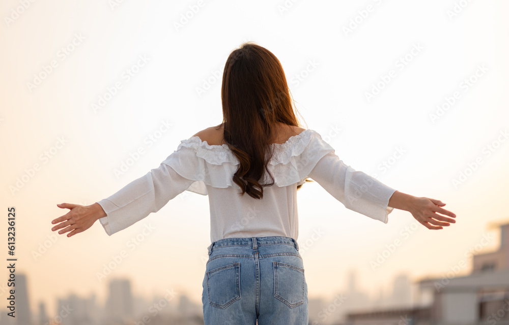 Happy Asian woman standing over city background outdoor. Relaxing with ...