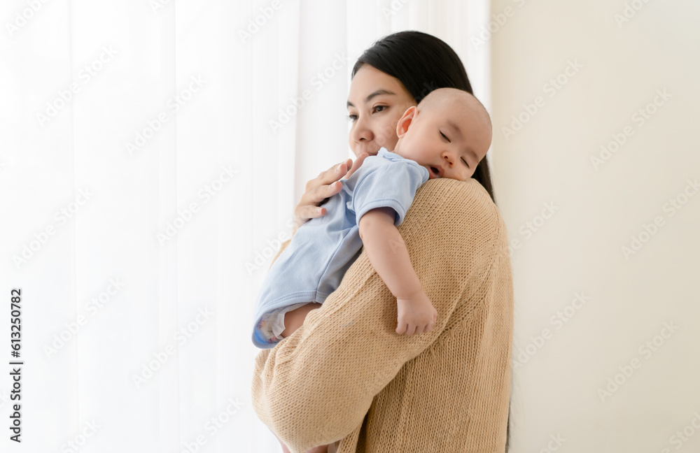 Loving Asia mom carying of her newborn baby at home. Caring young Asian ...