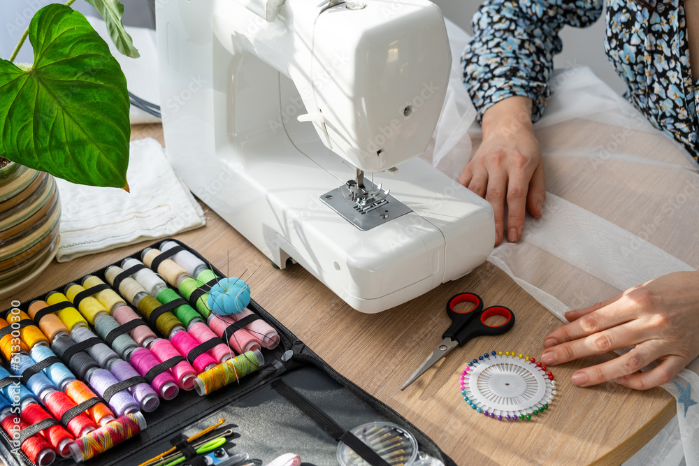 Woman hand close up sews tulle on electric sewing machine. Filling the ...