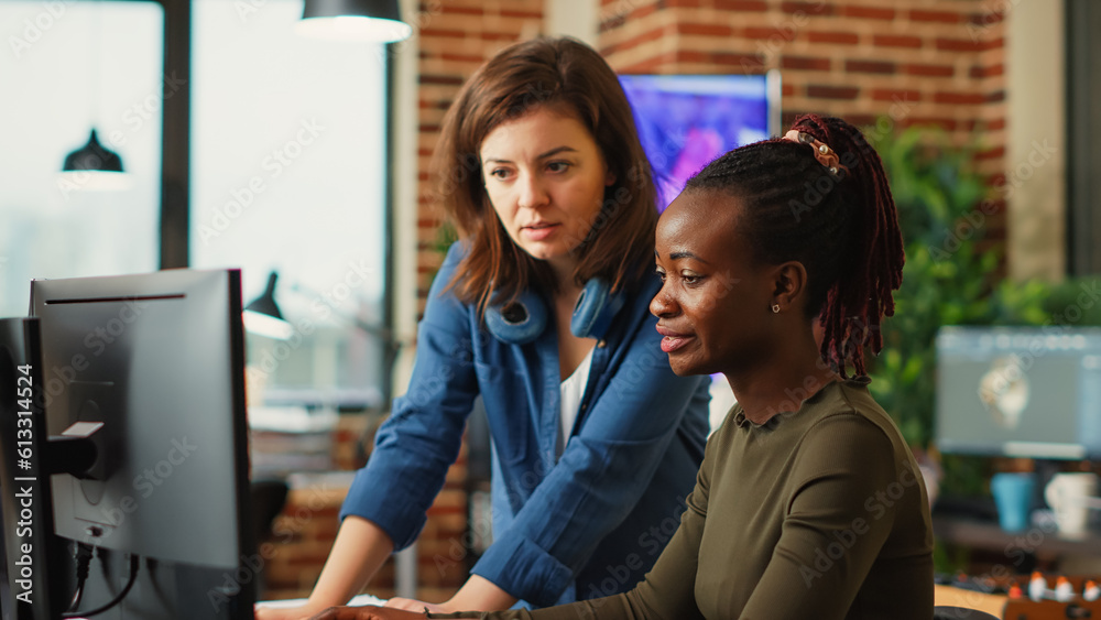 Team of diverse office employees working on multi monitors to create ...