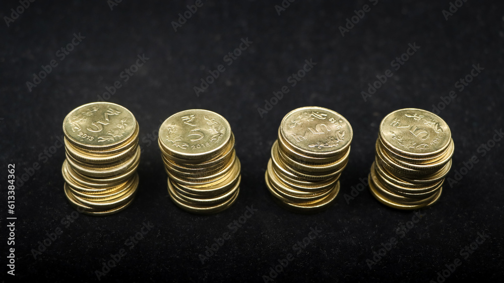 stacks of vintage indian gold 5 or five rupee coins divided equally and ...