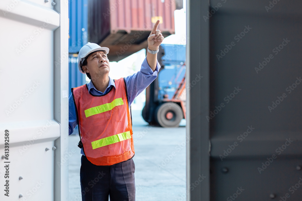 Foreman safety helmet checking inside containers in cargo ship ...