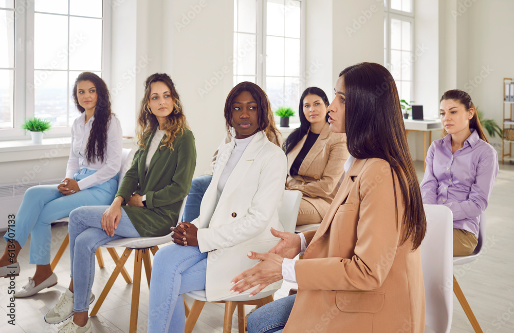 Diverse women gathered together listening business coach at seminar ...