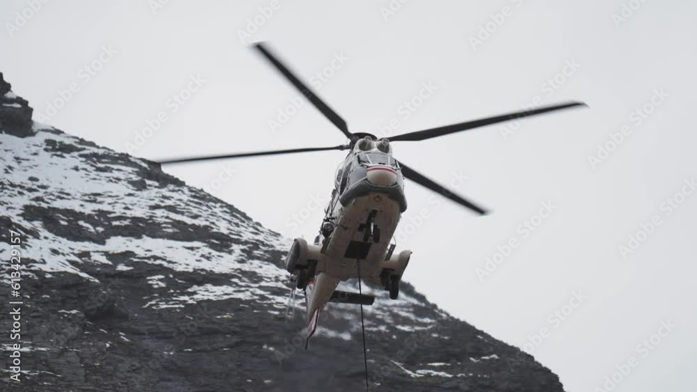 Cargo helicopter with lifting cable and load attached landing in the ...