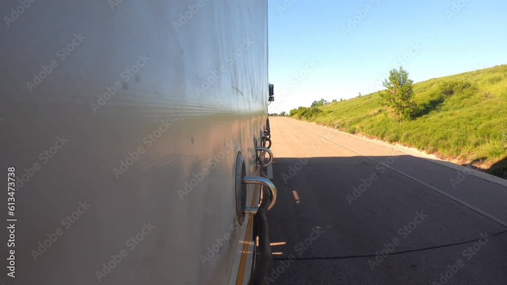 Lorry with goods driving on asphalt road at summer day. POV the side to ...