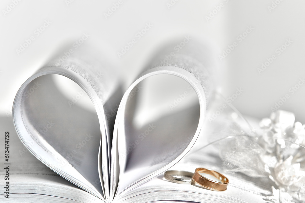 Wedding background.Blurred background of wedding rings and open book An ...
