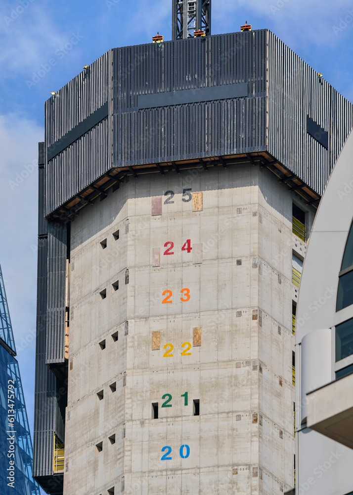 Tall modern skyscraper construction, concrete walls with numbers ...