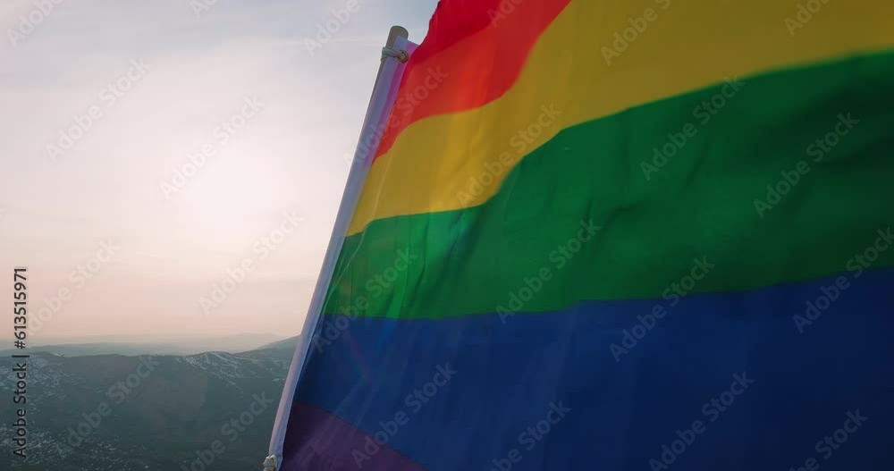 Rainbow LGBT waving flag on sunset sky. Message of love, acceptance and ...