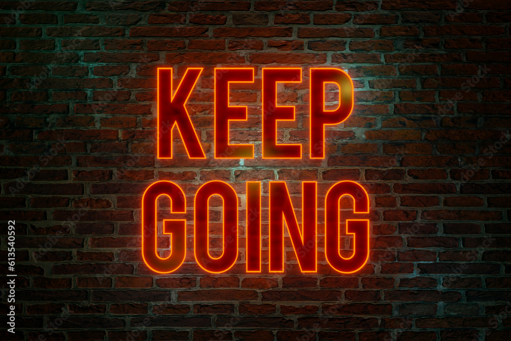 Keep going, neon sign. Brick wall at night with the text "Keep Going ...