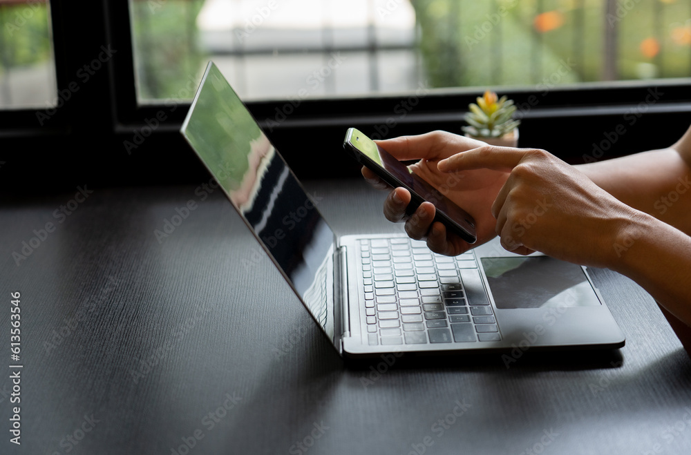 person's hand deftly manipulated both mobile phone and notebook ...