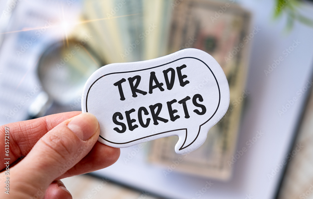 Businessman holding a card with text trade secret .Keyboard, diagram and white background Stock ...