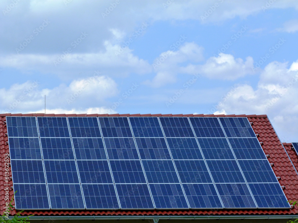 roof installed photovoltaic PV sun collector solar panels. clear blue ...