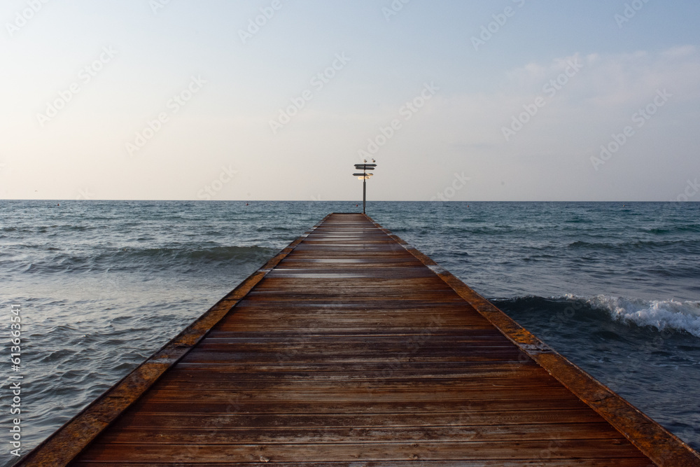 Foto de pontile sul mare con cartello e gabbiani do Stock | Adobe Stock