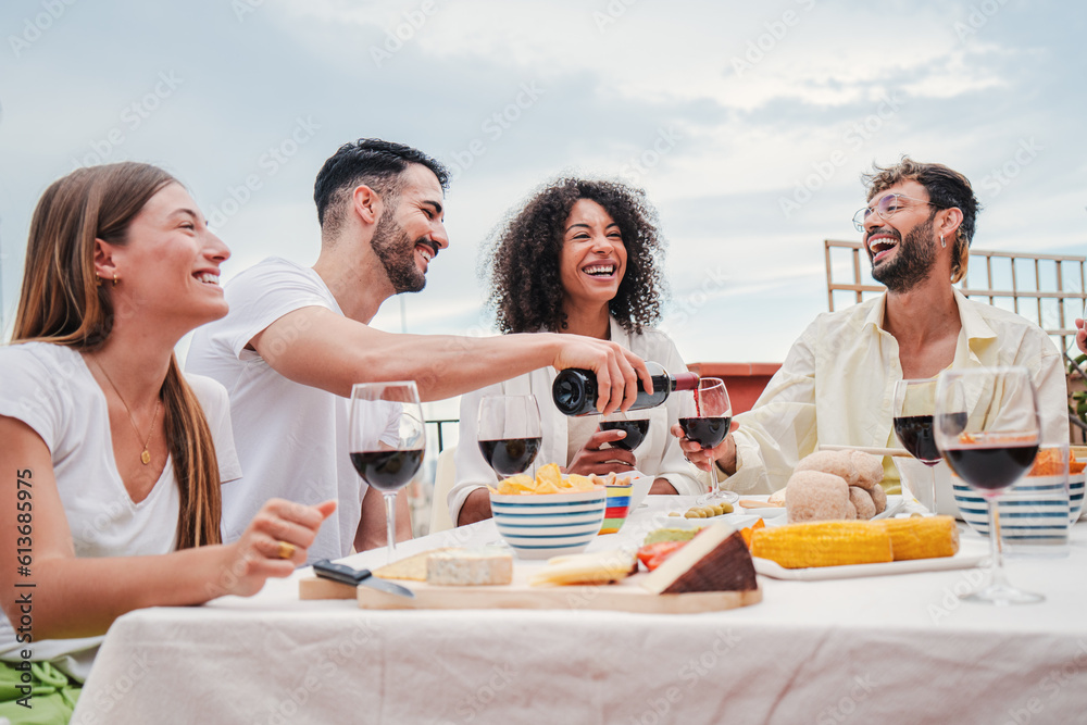Foto de Handsome man fill the wineglass of his brother at lunch or ...