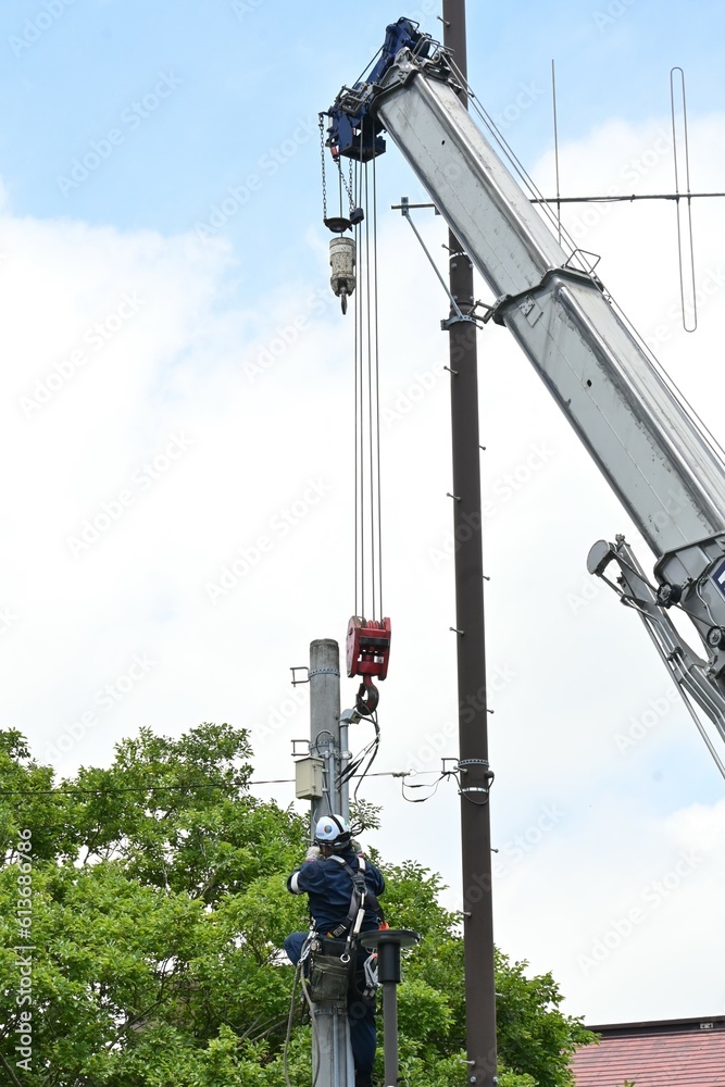 Removal work of iron poles and concrete poles by crane truck. A view of ...