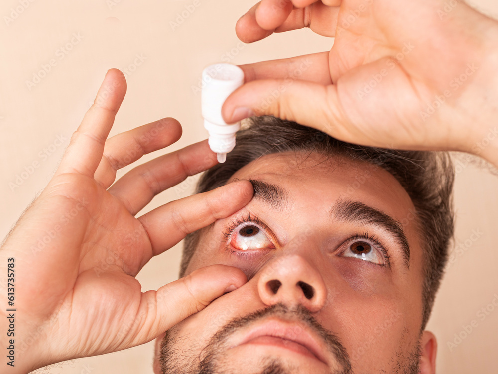 Close-up of man dripping his eye with medicinal drops natural tear ...
