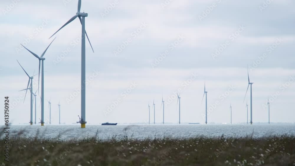 An offshore wind farm and boat in the early morning light. Windpark ...