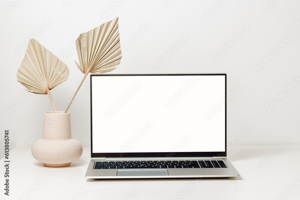 Laptop mockup with white screen and vase with palm leaf on the table ... Laptop mockup with white screen and vase with palm leaf on the table ...