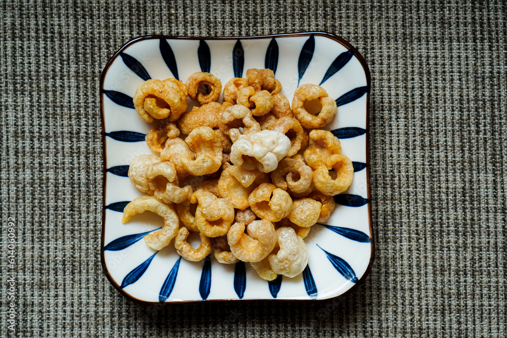 Foto de A top-view photo shows pork rinds on a ready-to-eat plate, pork ...